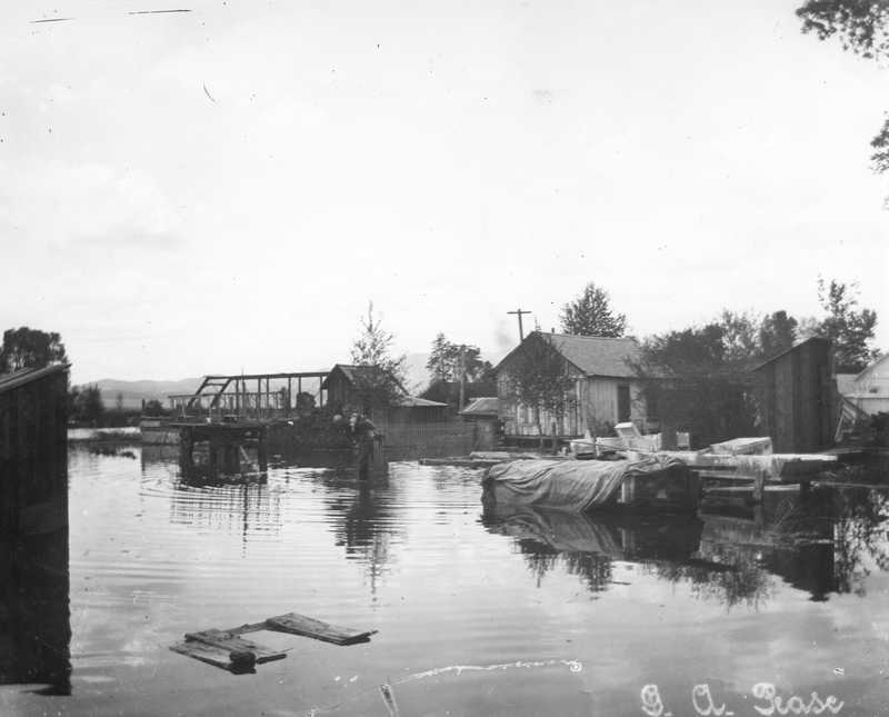 Flood of standing water, surrounded buildings, and piles of tarp ...