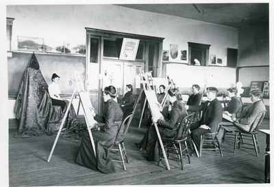 Class of art students sketching a woman